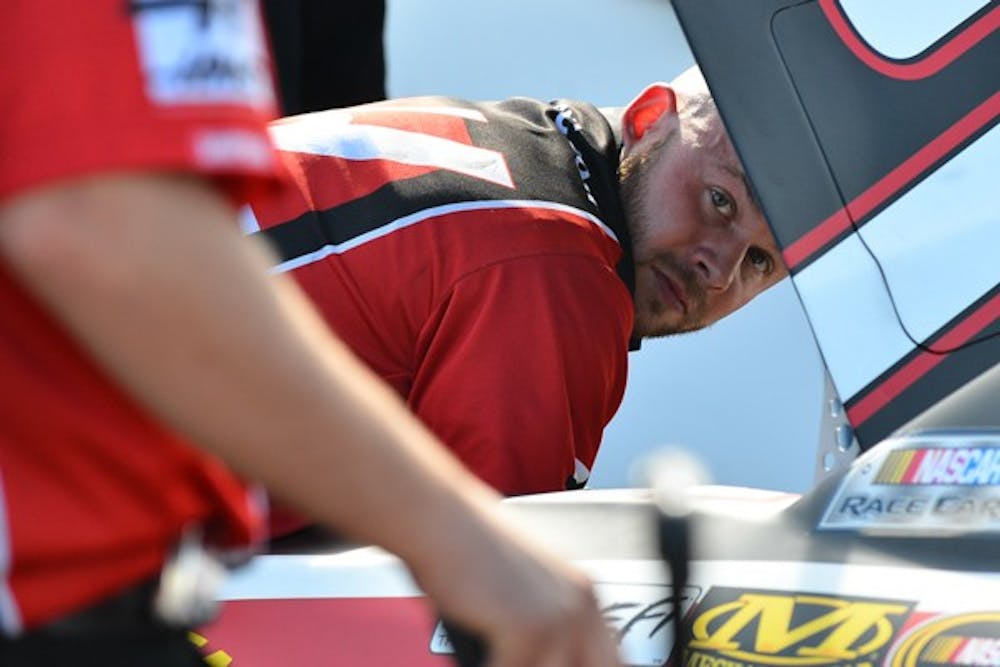 A mechanic glances at passersby while working on a car. - The Arizona ...