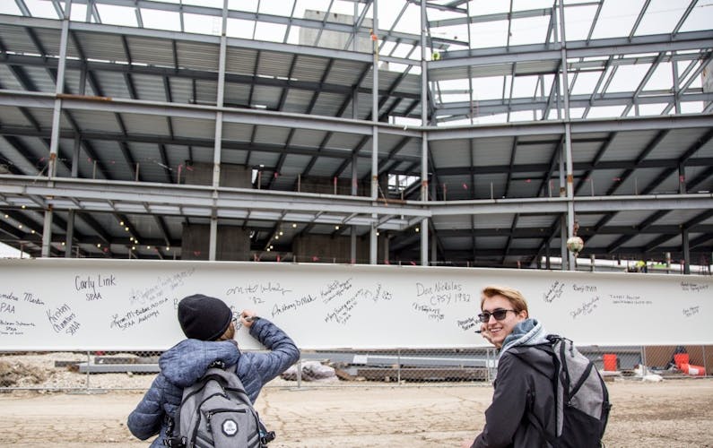 Students sign beam at Health Professions Building - Ball State Daily