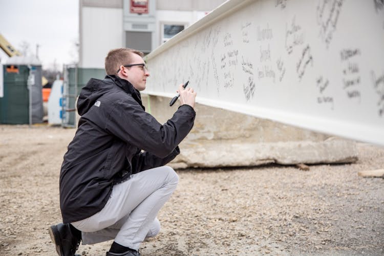 Students sign beam at Health Professions Building - Ball State Daily